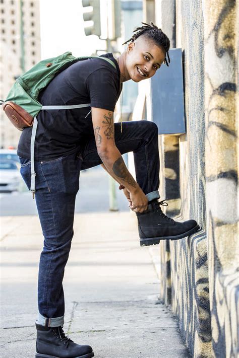 Androgynous Mixed Race Woman Carrying Backpack Adjusting Boot Stock Photo