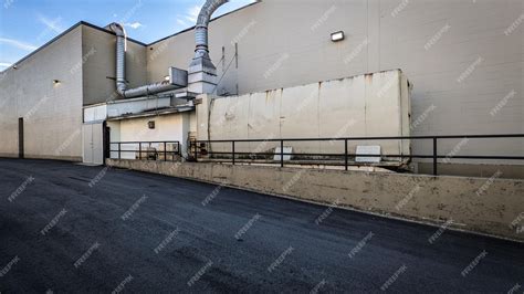 Premium Photo Rusty Industrial Garbage Compactor Against A White Building