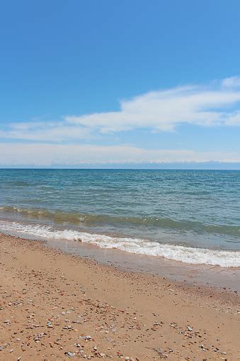 푸른 하늘과 산에 자갈이 있는 파도와 젖은 모래가 있는 해변 바다 바다 배경입니다 휴가 야외 및 여행 휴가 모험 개념 세로 0명에 대한 스톡 사진 및 기타 이미지 Istock
