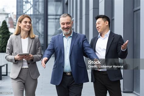 It 전문가로 구성된 다양한 팀 선임 및 숙련 된 엔지니어 관리자 팀 리더 사무실 건물 밖에서 행복하게 산책하는 세 명의 근로자 그룹 비즈니스 슈트를 입은 동료 스폰서에