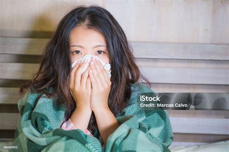 젊은 아름 답 고 달콤한 아시아 한국 여자 잠 옷에 덮여 담요 아픈 고통 감기와 독감 침대 느낌 기침 하는 그녀의 코를 불고 열이 온도계로 온도 복용 감기와 독감에 대한