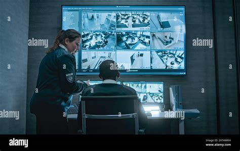 Female Security Employee Talks With African American Coworker Uses Tablet Multiethnic