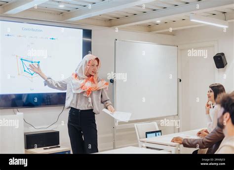 Female Businesswoman Pointing To The Presentation On The Tv In The Semniar Meeting Stock Photo