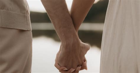 물가에서 손을 잡고 있는 로맨틱한 커플 · 무료 스톡 사진