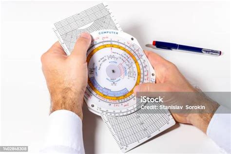 미래의 조종사 인 비행 아카데미의 생도는 여객기의 성능 계산에 관한 수업 중에 비행 네비게이션 컴퓨터를 손에 쥐고 있습니다 비행 훈련 개념 공항에 대한 스톡 사진 및 기타