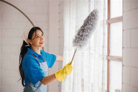 Asian Woman Smiles Dusting Window Blinds With A Duster Her Routine Cleaning Stock Image Image