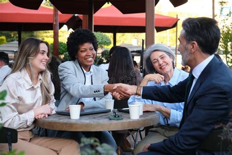 Business People Shaking Hands During A Meeting At Outdoor Cafe Stock
