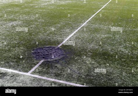 A Hole In The Ground From A Cannon Shell Explosion Filled With Fresh Earth At A Football Stadium