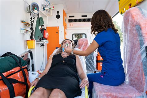 전염병 중 구급차에서 호흡기 환자를 돕는 얼굴 마스크를 가진 여성 간호사 구급대원 들것에 대한 스톡 사진 및 기타 이미지