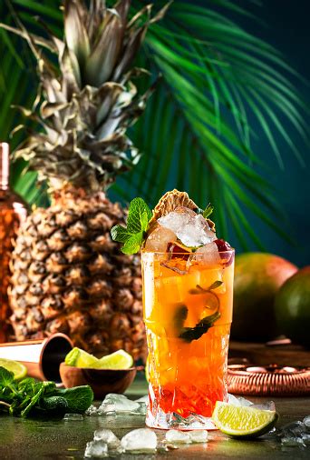 보드카 파인애플 주스 망고 붉은 시럽과 얼음 알코올 칵테일 긴 음료 또는 여름 차가운 목테일 야자수 잎과 이국적인 과일이있는 열대 어두운 배경 칵테일에 대한 스톡 사진 및
