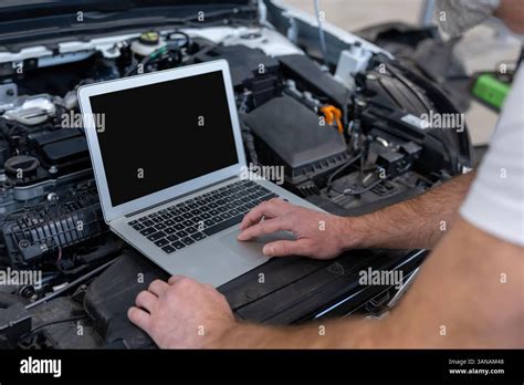 Mechanic man mechanic using laptop computer checking car Stock Photo - Alamy
