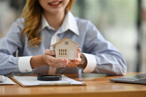 서류가 있는 모델 하우스를 들고 있는 손의 클로즈업과 배경에 돋보기를 들고 있는 모습은 부동산 또는 주택 소유 계획을 나타냅니다 개발에 대한 스톡 사진 및 기타 이미지