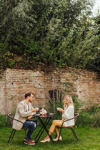 여자 친구와 남자 친구 컵 커피와 테이블에 꽃다발의 카페 테이블에 앉아의 측면 보기 건축에 대한 스톡 사진 및 기타 이미지 건축 꽃 식물 나무 Istock