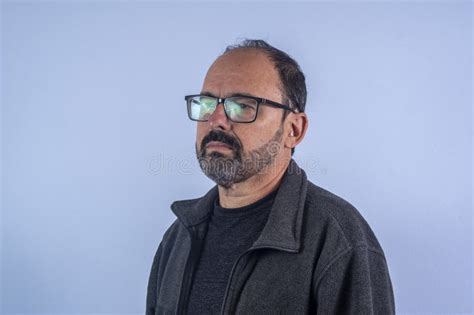 Portrait Of 60 Years Old Bearded Man On Blue Background With Hat And