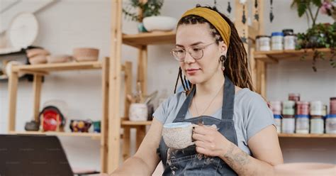 젊은 여성 프리랜서 또는 중소기업 소유주가 직장 옆 노트북 앞에 앉아 차를 마시며 인터넷에서 새로운 아이디어를 찾고 있다 사진 Unsplash의 기술 이미지