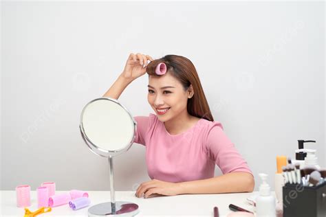 Happy Woman Admiring Her Beauty With Curlers In Front Of The Mirror