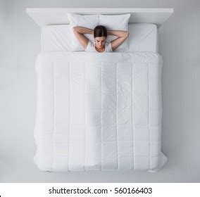 美丽的年轻女子躺在床上睡觉，顶视图库存照片560166409 Shutterstock