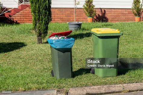 호주 쓰레기 바퀴달린 쓰레기통에는 일반 및 재활용 가정용 쓰레기 수거 후 길가에서 가정용 쓰레기를 재활용하기 위한 다채로운 뚜껑이 있는 쓰레기통 가정 생활에 대한 스톡 사진
