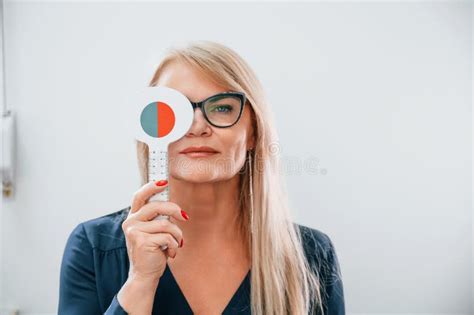 Woman Sitting In The Clinic And Covering Her Eye Testing Vision Stock