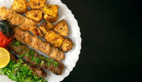 구운 치킨 샤슬릭 양고기 쇠고기 코프타 케밥 토마토 어두운 나무 배경에 흰색 접시에 파슬리 복사 공간 상단 보기 레바논 문화에