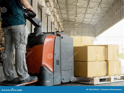 Warehouse Worker Driving Electric Forklift Pallet Jack Loading Shipment Boxes Stack Package