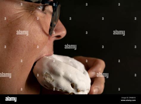 Woman In Profile With Glasses Taking A Bite Of A Glazed Sugar Doughnut