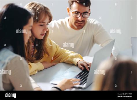 Young Girls Engaging In A Computer Class With A Teacher Guiding Them