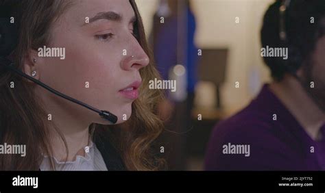 Telemarketers Communicating With Clients Wearing Headsets In Front Of