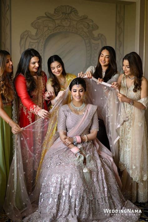 Bridesmaids Fixing The Brides Outfit On Her Wedding Functions