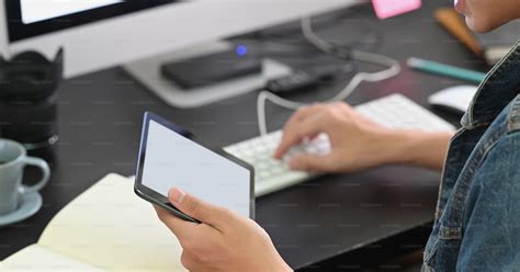 똑똑한 남자가 흰색 빈 화면 태블릿을 들고 검은색 작업 책상에서 키보드로 타이핑하고 있습니다 사진 Unsplash의 컴퓨터 키보드 이미지