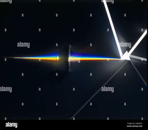 white light passing through glass prism to form colour spectrum stock