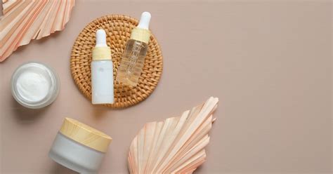 스킨케어 제품 세트 유기 보습제 크림 항아리 스포이드 병에 에센셜 오일과 혈청 베이지 색 배경에 마른 꽃 잎 피부 치료를