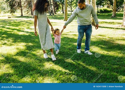 Familia De Madre Padre E Hijo Caminando Por El Parque Foto De Archivo