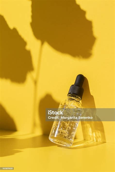 나뭇잎 그림자가있는 노란색 배경에 유리 점적기 병을 모의하십시오 화장품 얼굴 피부 관리 및 스파 자연 치료 개념 강단에 대한 스톡 사진 및 기타 이미지 Istock