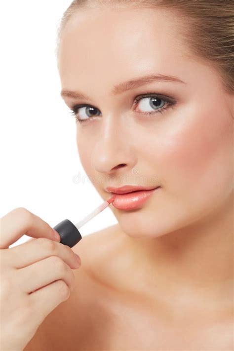 Fulling Out Her Lips A Stunning Young Woman Applying Lipgloss To Her Luscious Lips While