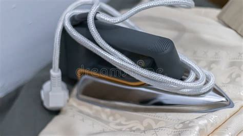 Iron And Folded Ironed Clothes On Ironing Board Isolated On Grey Stock