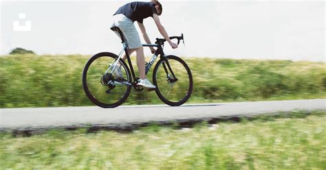 낮 동안 회색 아스팔트 도로에서 검은 산악 자전거를 타고 검은 셔츠를 입은 남자 사진 Unsplash의 무료 게제 이미지