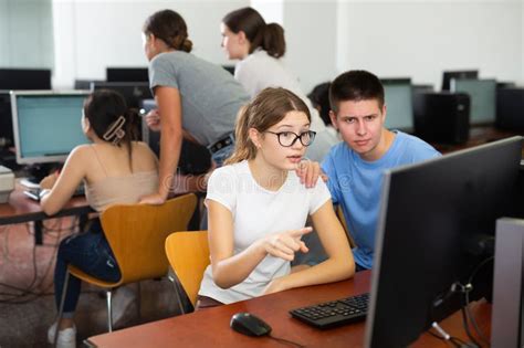 Clever Male Teenager Helping To The Female Classmate While She Is Learning Computer Science In