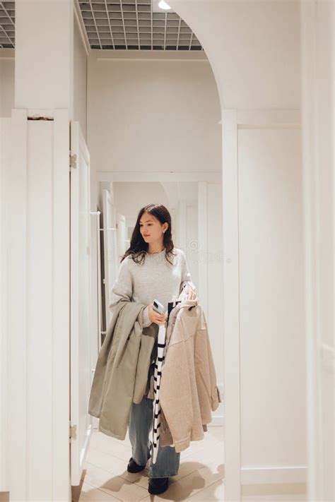 Korean Teenage Girl Trying Out New Trendy Clothes In The Cabin In A Shopping Mall Retail And