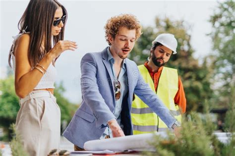 Architects Discussing Project Costs And Paperwork Outdoors Analyzing