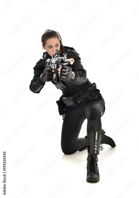 full length portrait of female wearing black tactical armour crouching