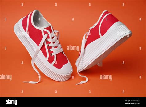 Pair Of Red Classic Old School Sneakers On Orange Background Stock