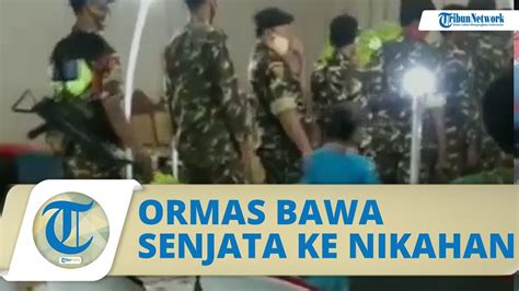 Viral Video Anggota Ormas Berbaju Loreng Bawa Senjata Laras Panjang Ke Kondangan Warganet