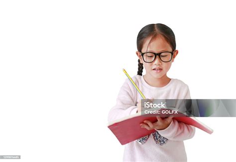 안경을 들고 안경을 쓰고 복사 공간이있는 흰색 배경에 연필로 된 노트북에 쓰는 작은 아시아 어린이 소녀를 의도합니다 4 5세에 대한 스톡 사진 및 기타 이미지 Istock
