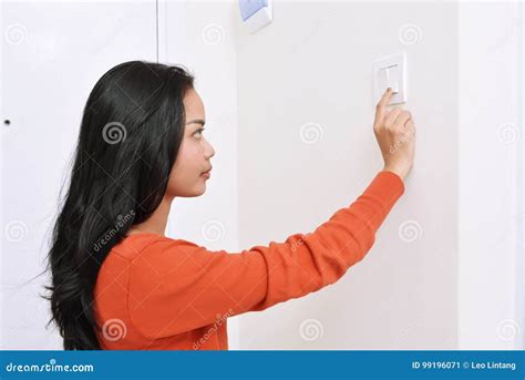 Beautiful Asian Woman Turning Off The Light With Wall Switch Stock