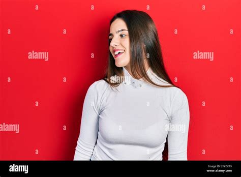 Young Brunette Teenager Wearing White Sweater Looking To Side Relax