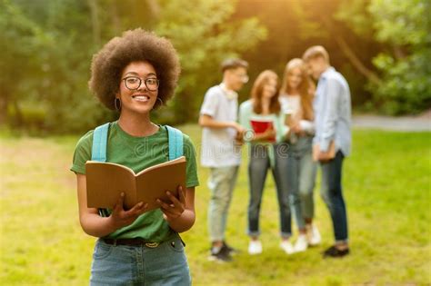 Smiling Nerd Black Girl Posing With Book Outdoors At Campus Stock Photo Image Of Black