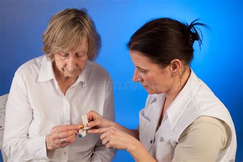 De Verpleegster Helpt Een Bejaarde Met Haar Medicijn Stock Afbeelding Image Of Griep Helpen