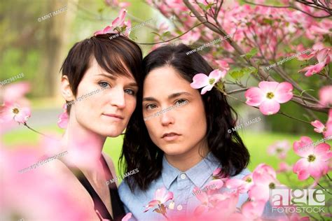 A Same Sex Couple Two Women Under The Branches Of A Flowering Tree Stock Photo Picture And