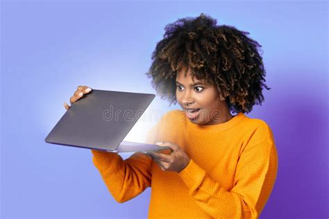 surprised african american woman open laptop and looking at sceen stock